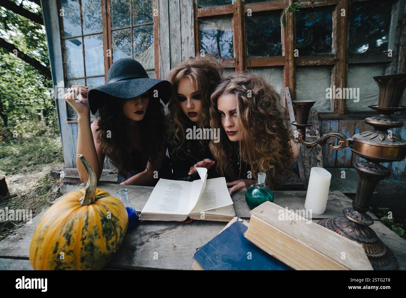 Three vintage witches perform magic ritual Stock Photo - Alamy
