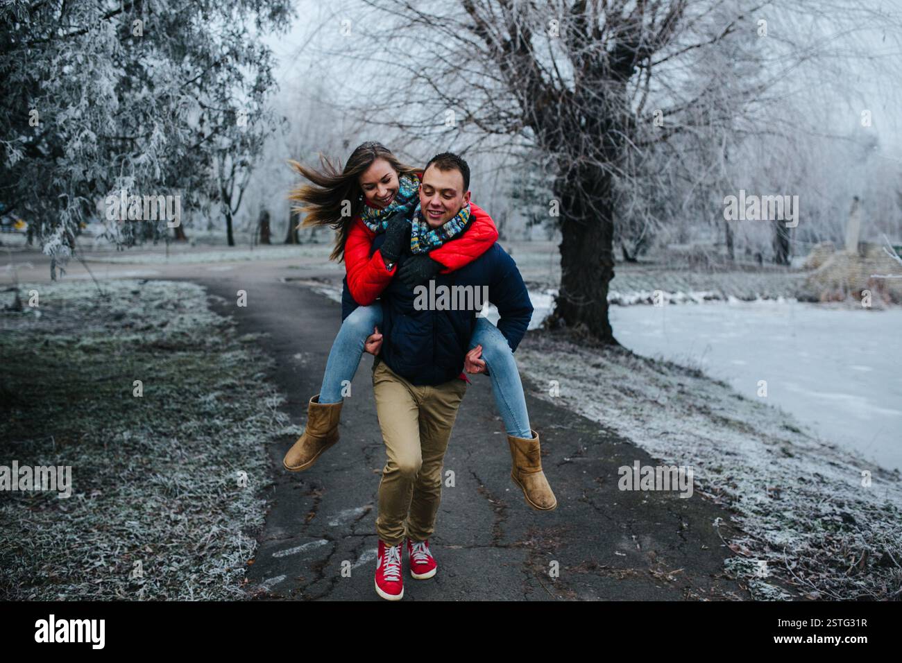 Man carries his girlfriend on his back in the park hi-res stock ...