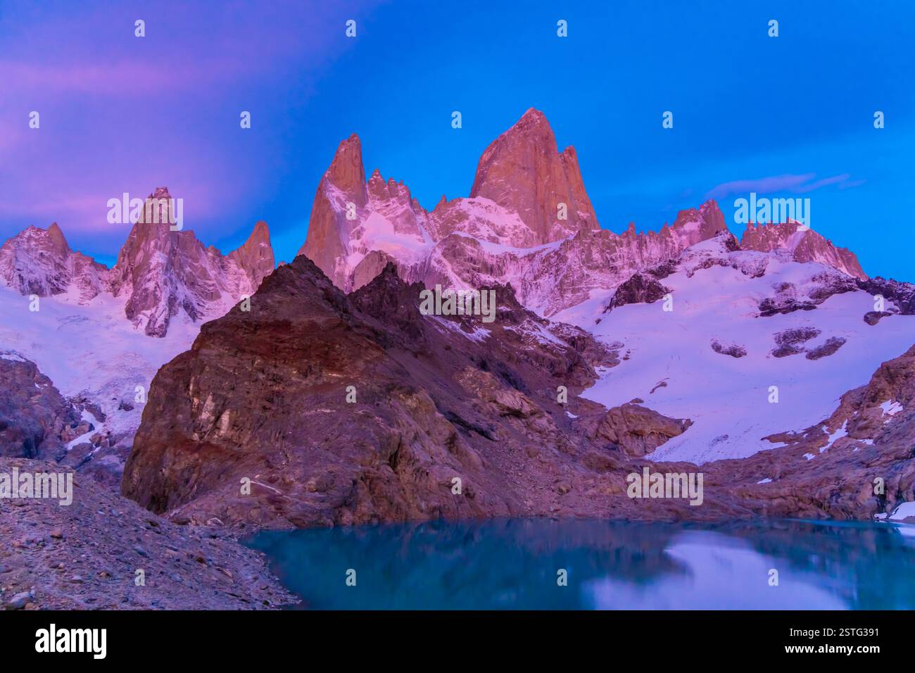 Fitz Roy sharp mountain peaks rise above a serene glacial lake ...