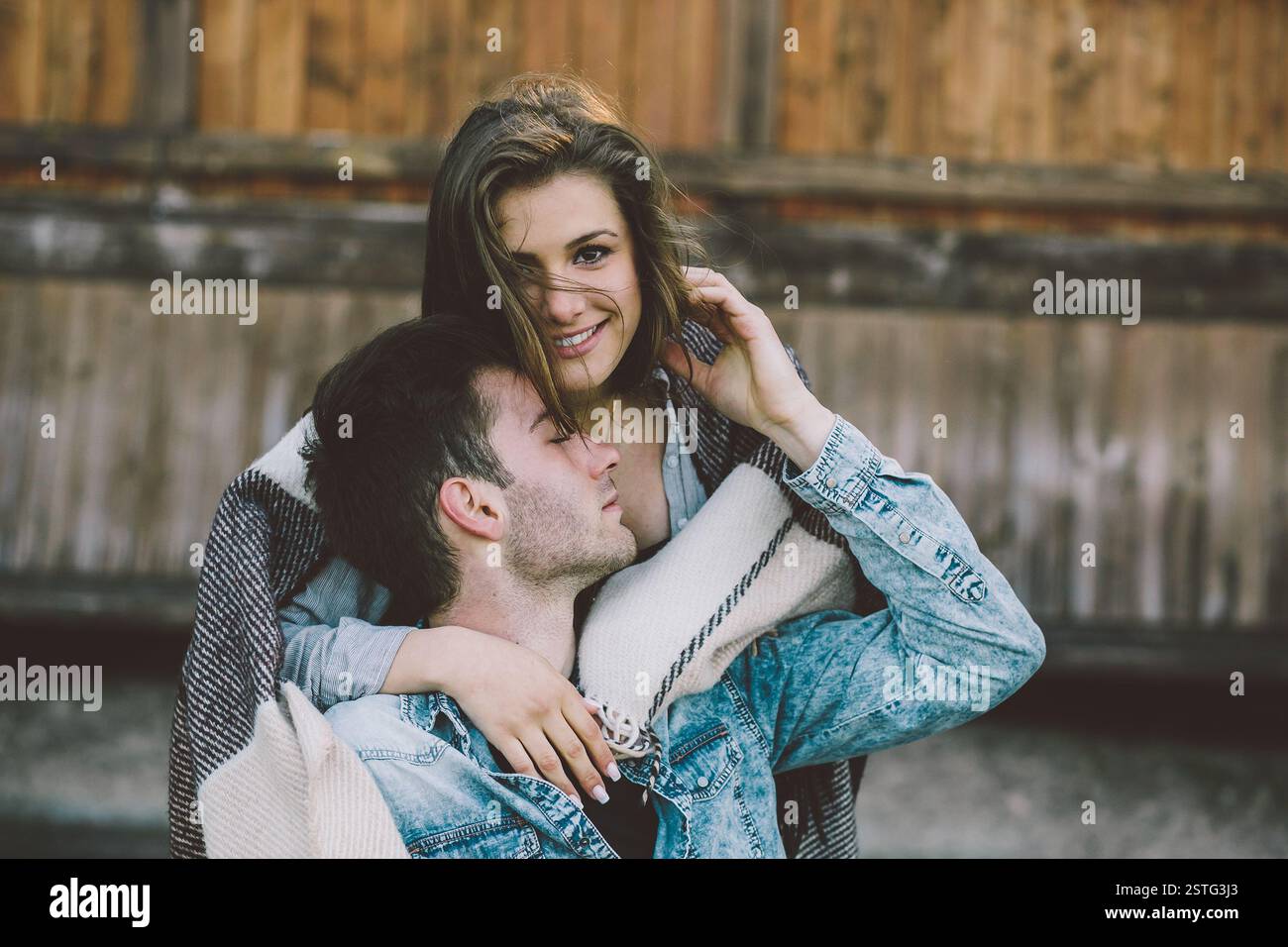 Young couple in love wrapped in plaid standing and embrace Stock Photo ...