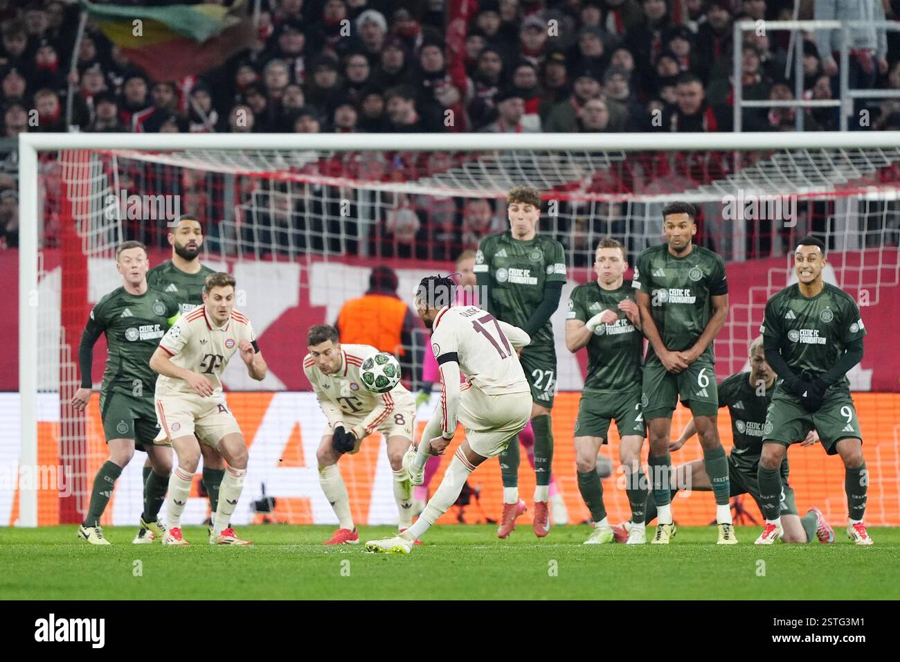 Bayern Munich's Michael Olise (centre) attempts a shot on goal from a ...