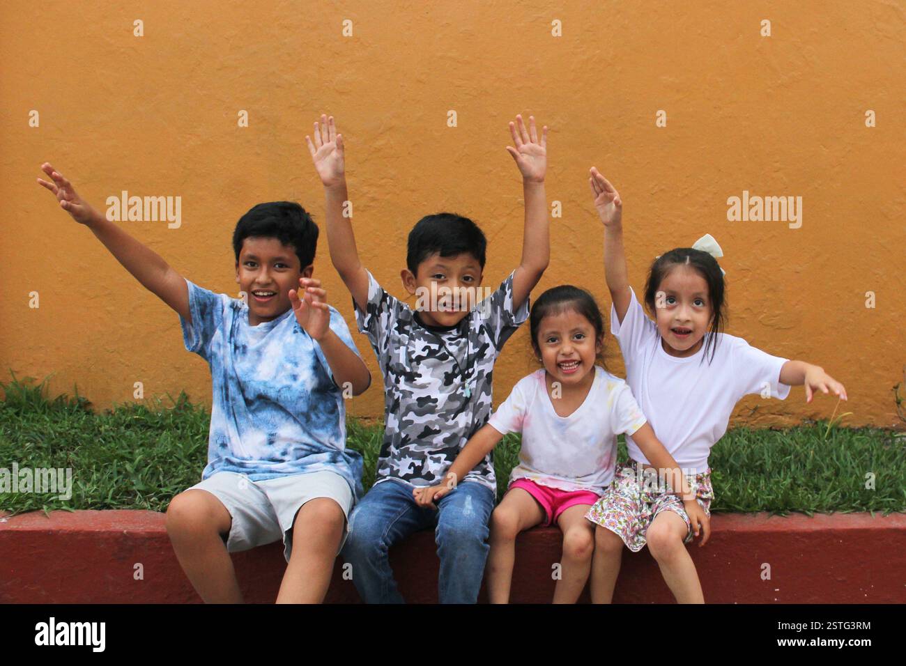 Two happy and excited dark-skinned Latino boys and 2 girls celebrate ...