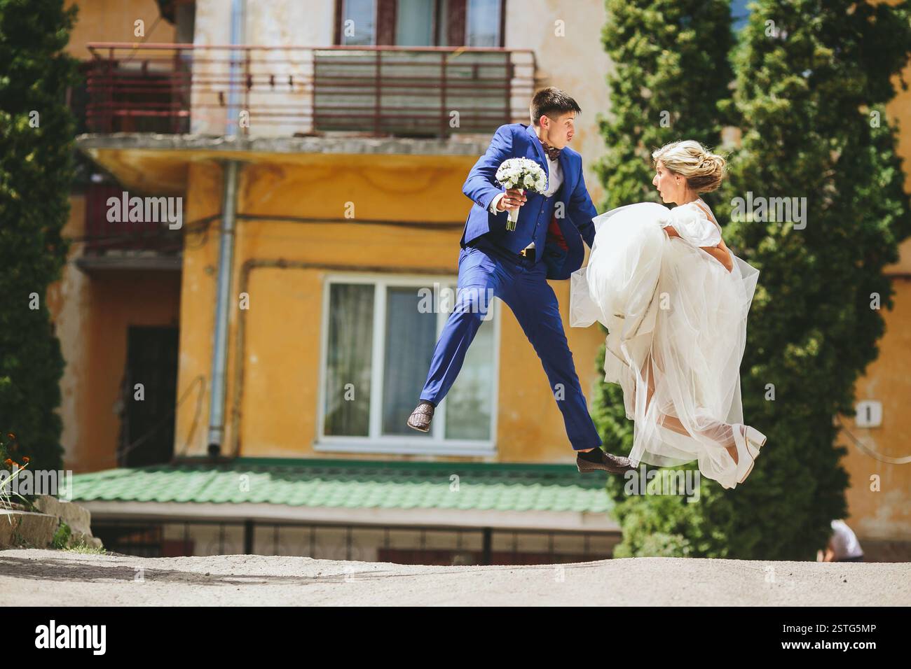 Couple jumping on the street Stock Photo - Alamy