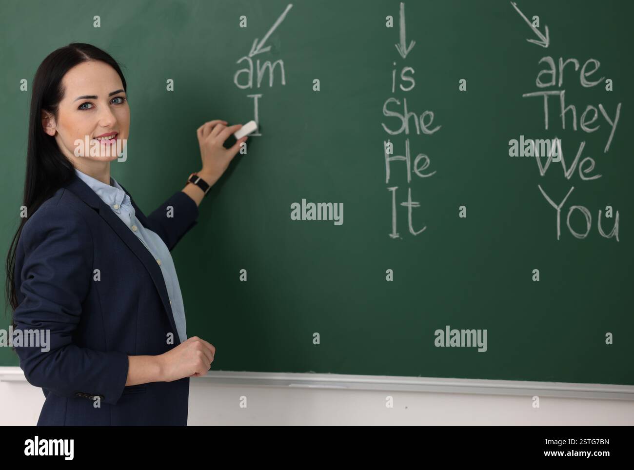 English teacher during lesson near chalkboard in classroom Stock Photo ...