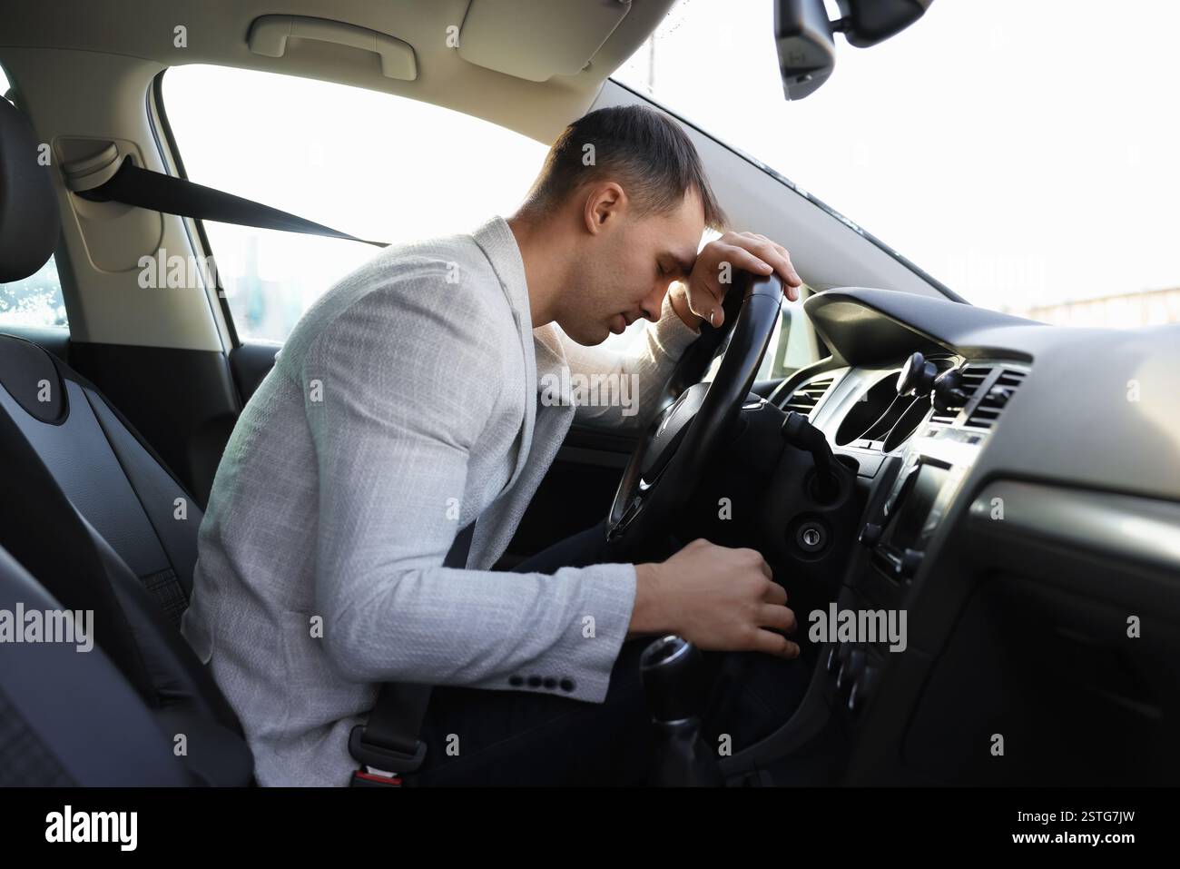Tired driver sleeping on steering wheel in car Stock Photo - Alamy