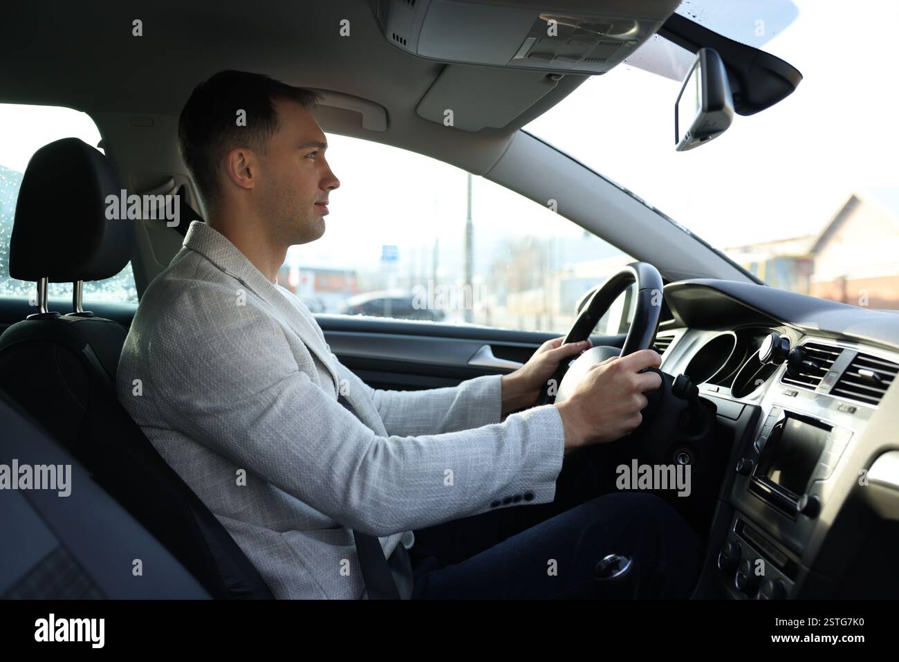Driver behind steering wheel of modern car Stock Photo - Alamy