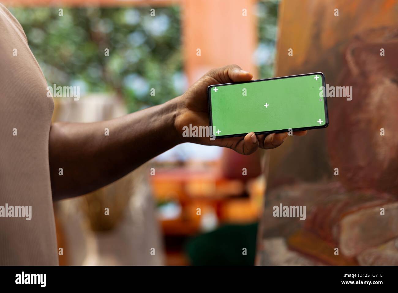 Young artist looking at isolated chroma key display in his painting ...
