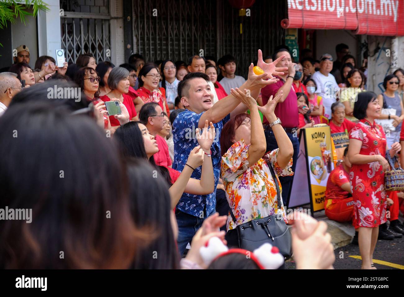 Kuala Lumpur, Malaysia. 16th Feb, 2025. People try to catch an orange ...