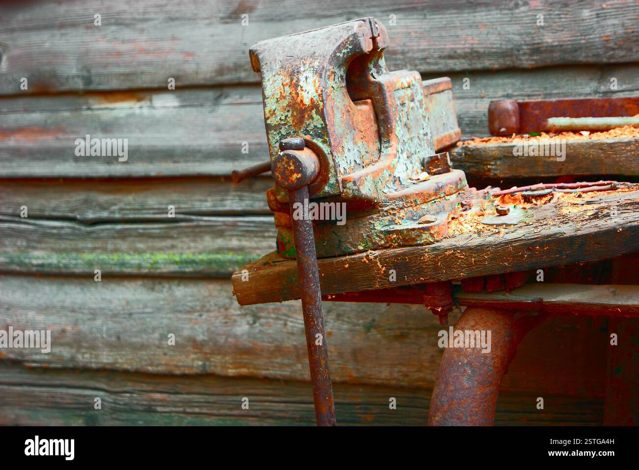 Old rusty vise on workbench of obsolete wood, a lot of space for text ...