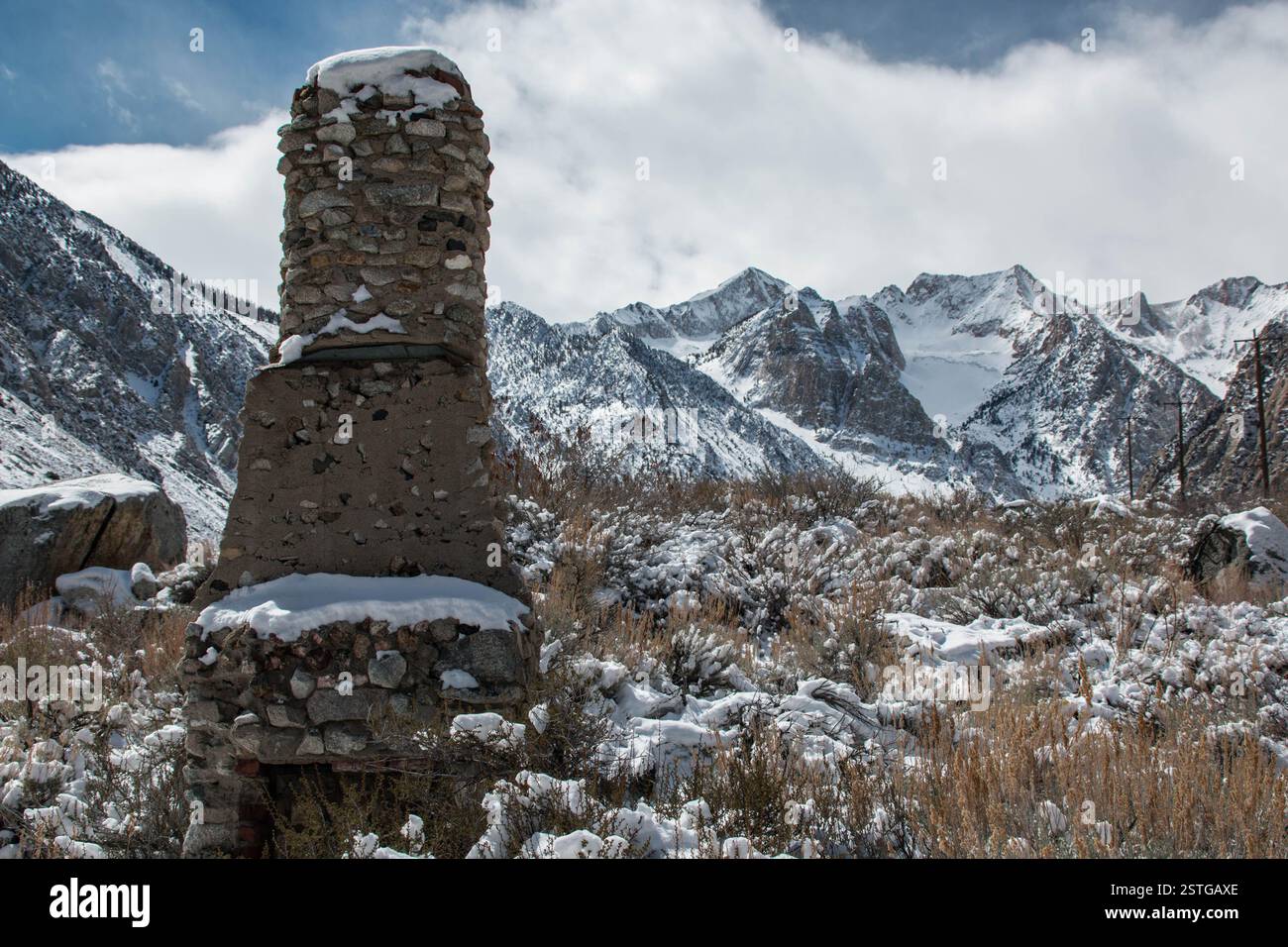 A snow covered stone chimney and fireplace are all that remain of an ...