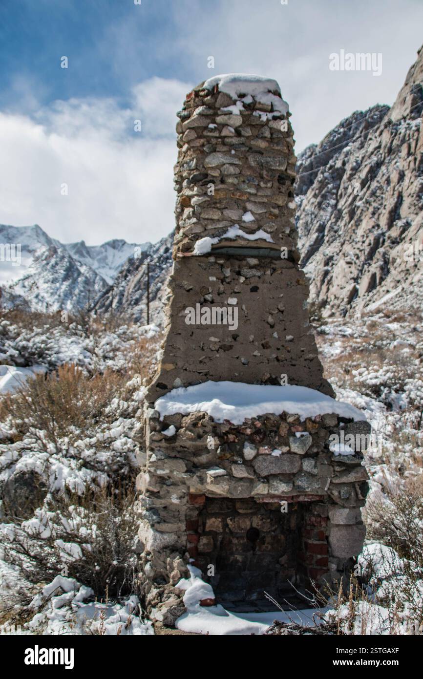 A snow covered stone chimney and fireplace are all that remain of an ...