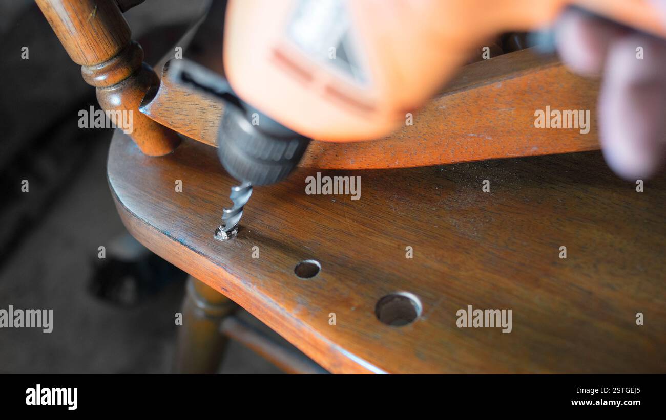 Drilling. Repairing of old chair. Selective focus on drill, shallow dof ...