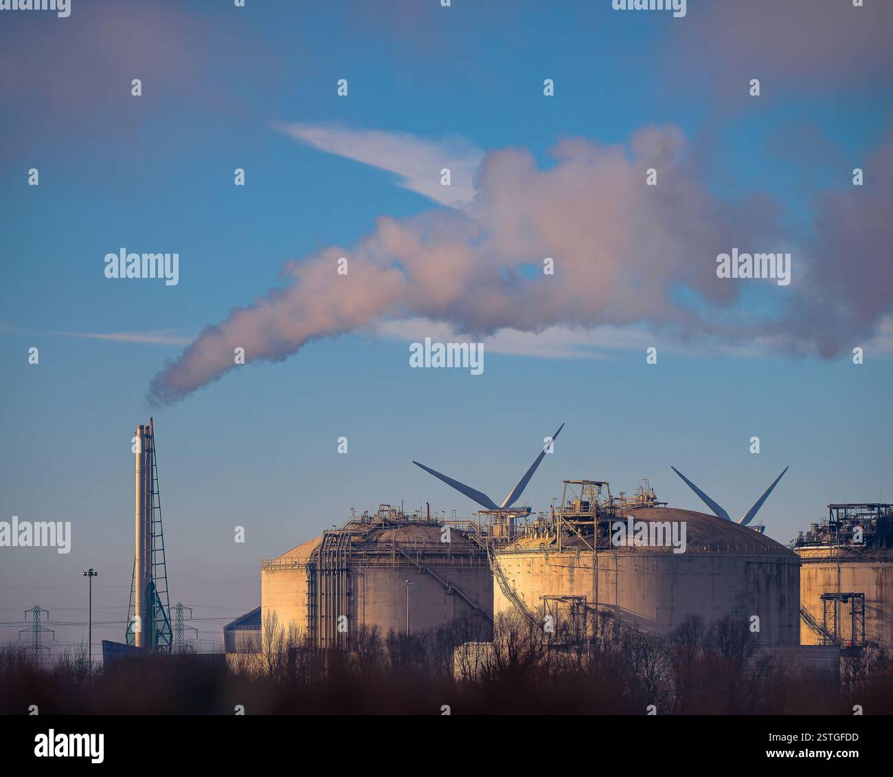Giant industrial vats near a refinery in an industrial zone against a ...