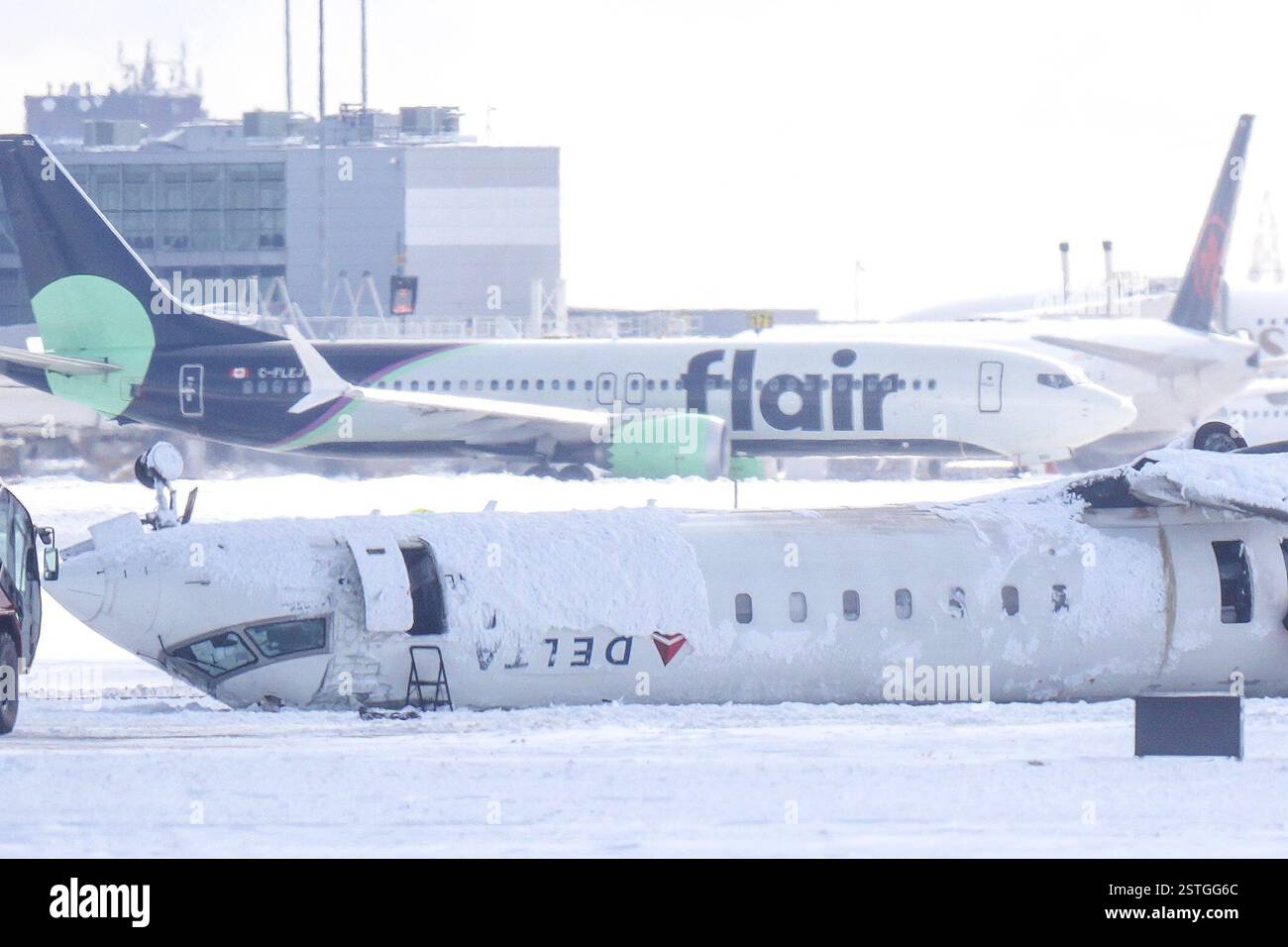 Toronto, Can. 18th Feb, 2025. A Delta Air Lines plane lies upside down ...