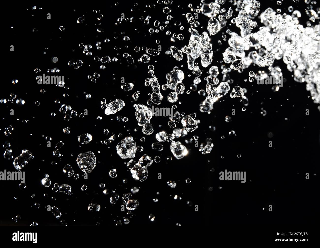 Water splash isolated on black background. drops levitate in the air ...