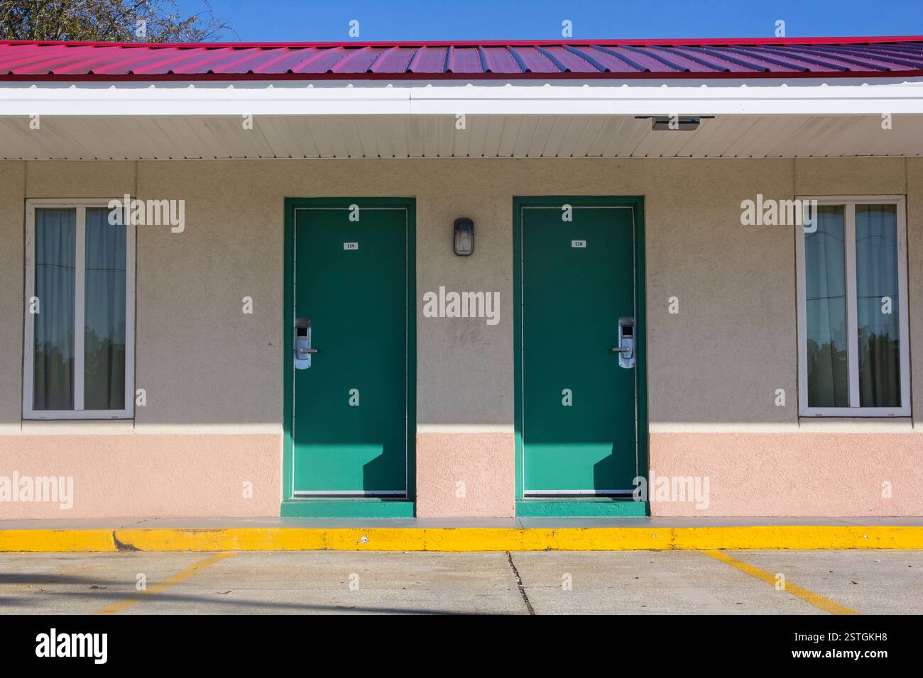 Vintage motel with pink roof and vibrant green doors, highlighting the ...