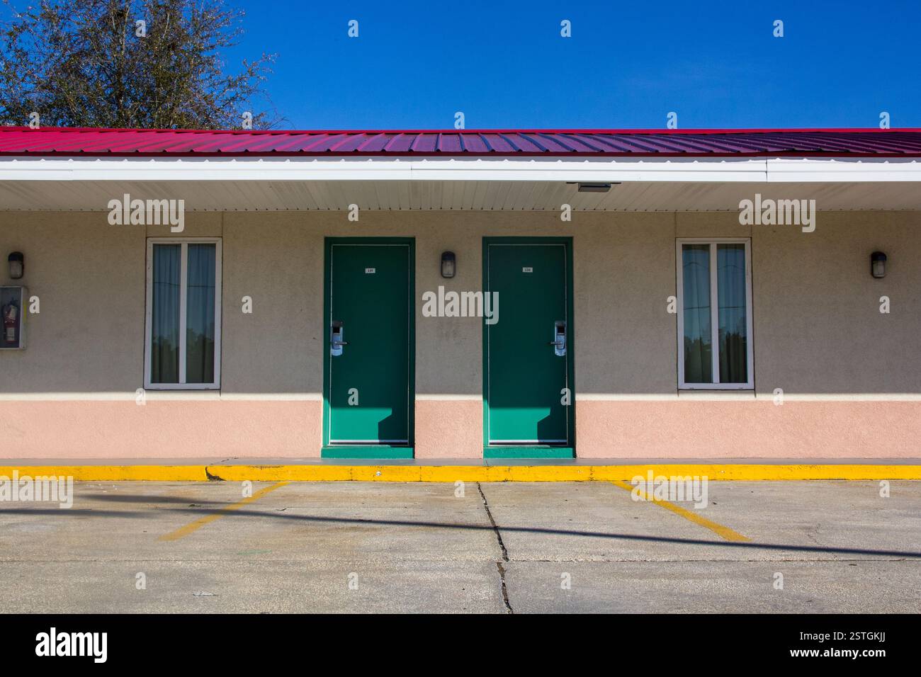 Retro style motel with pink roof and green doors, highlighting the road ...