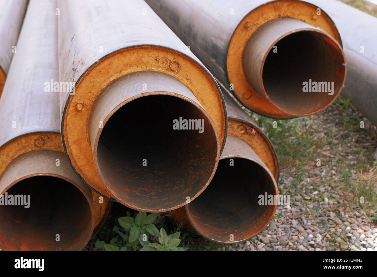 Steel water pipes with PVC isolation shell in stack on ground in ...