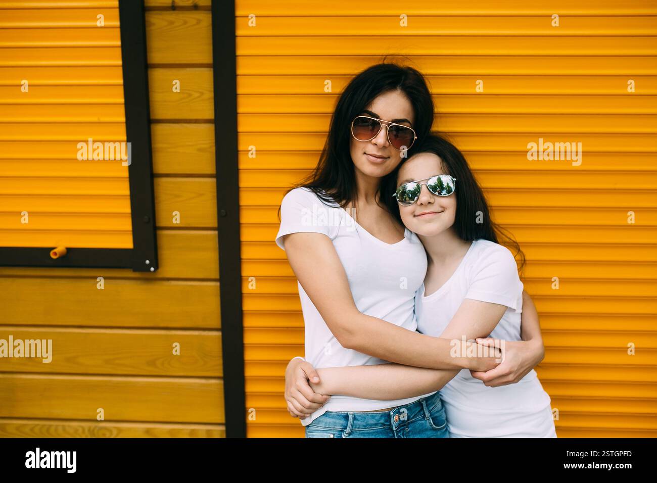 Mother and her cute daughter, against wall Stock Photo - Alamy