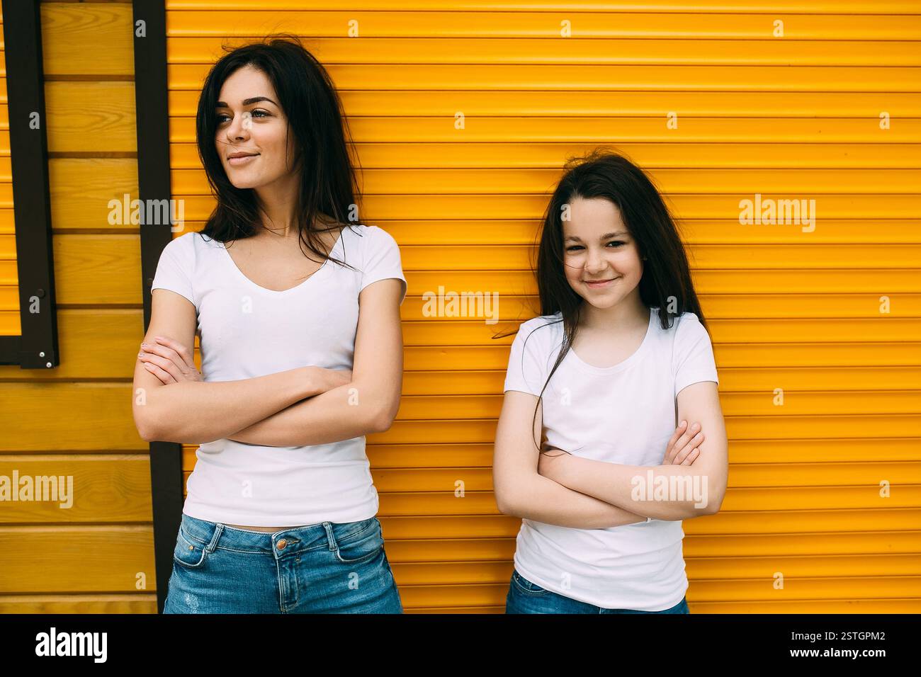 Mother and her cute daughter, against wall Stock Photo - Alamy