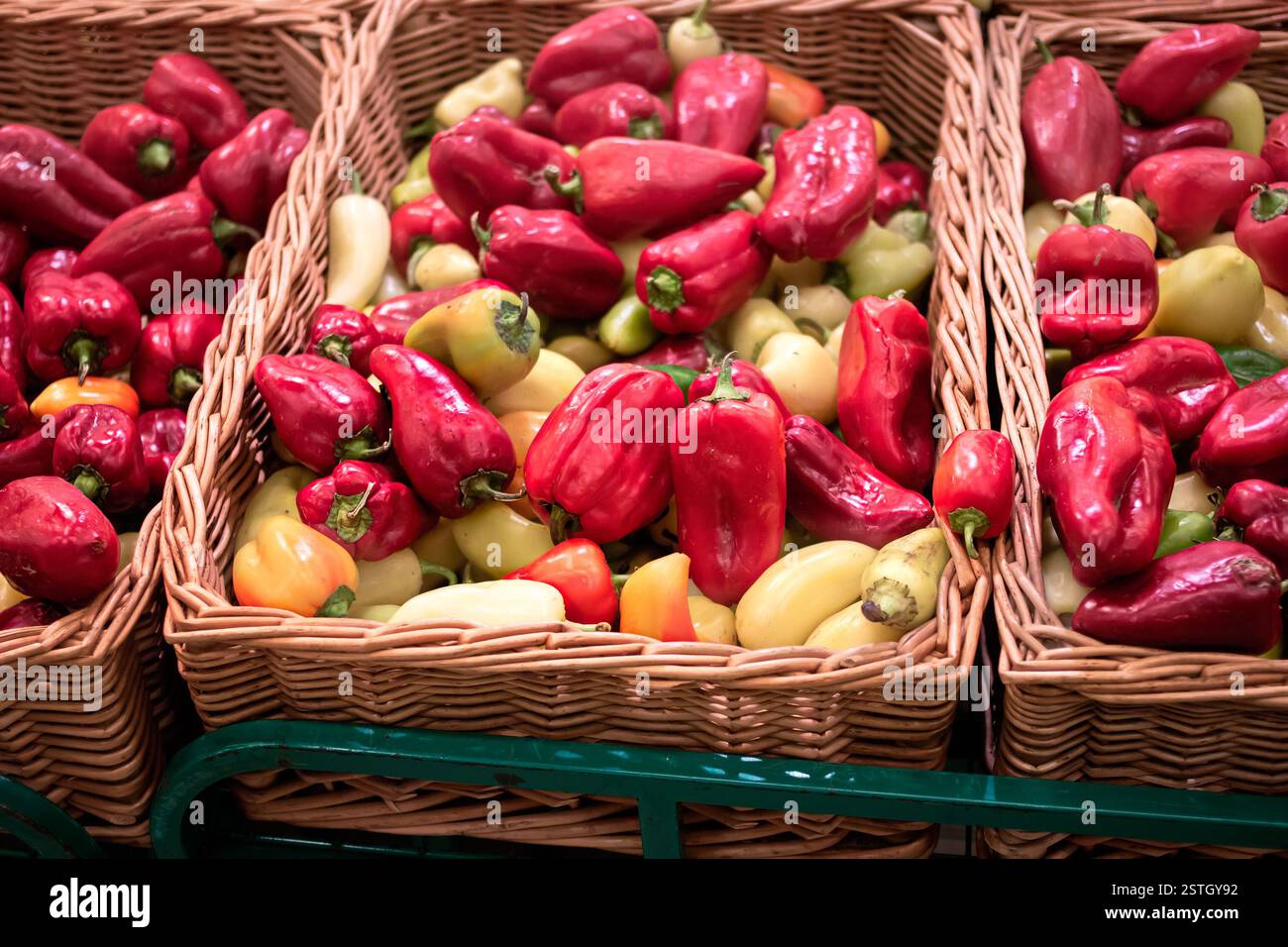 Bunch of red and yellow paprika peppers in wicker boxes in supermarket ...