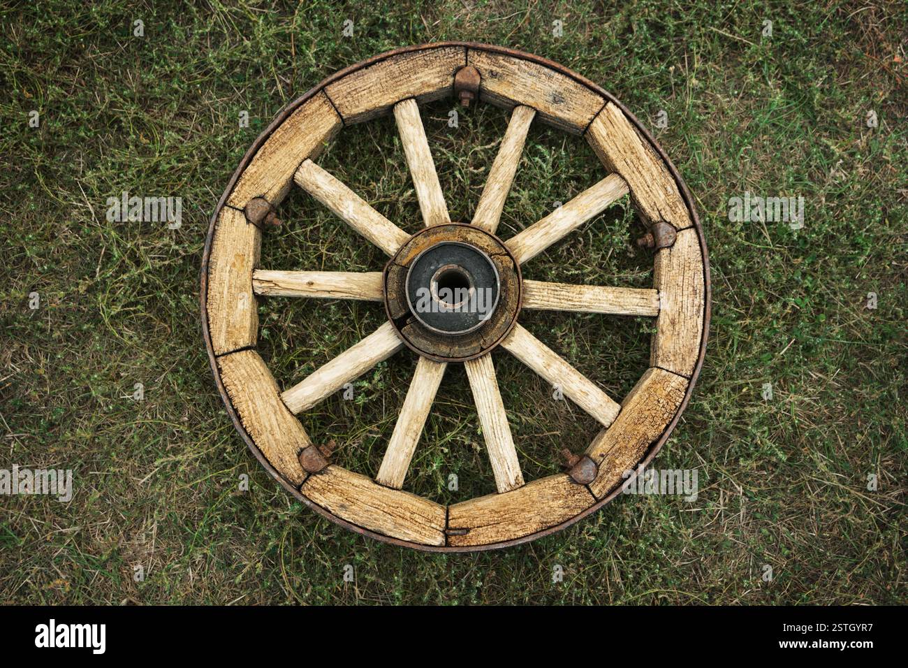 Old wooden wagon wheel on the grace Stock Photo - Alamy