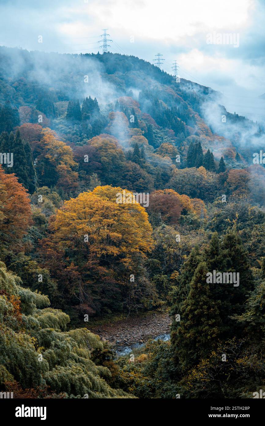 A serene autumn sunset over a small river, forest, and hills in rural ...
