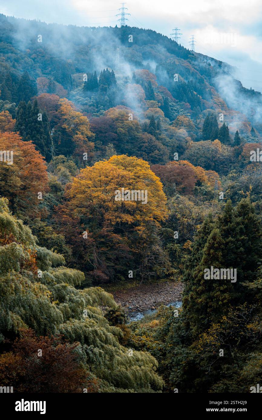 A serene autumn sunset over a small river, forest, and hills in rural ...