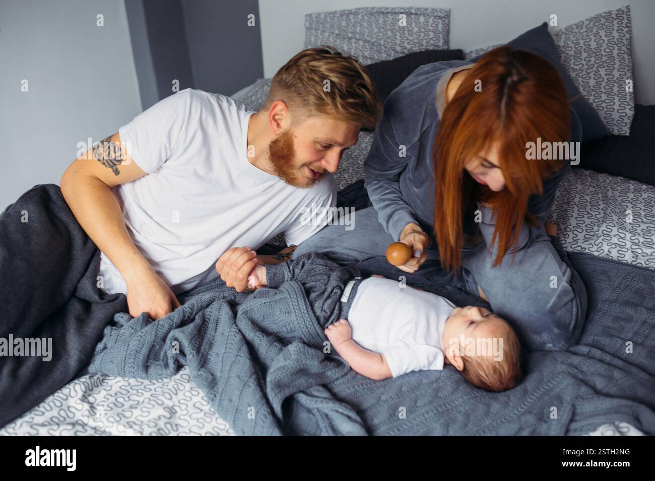Young parents giving lots of attention to their baby. They are all ...
