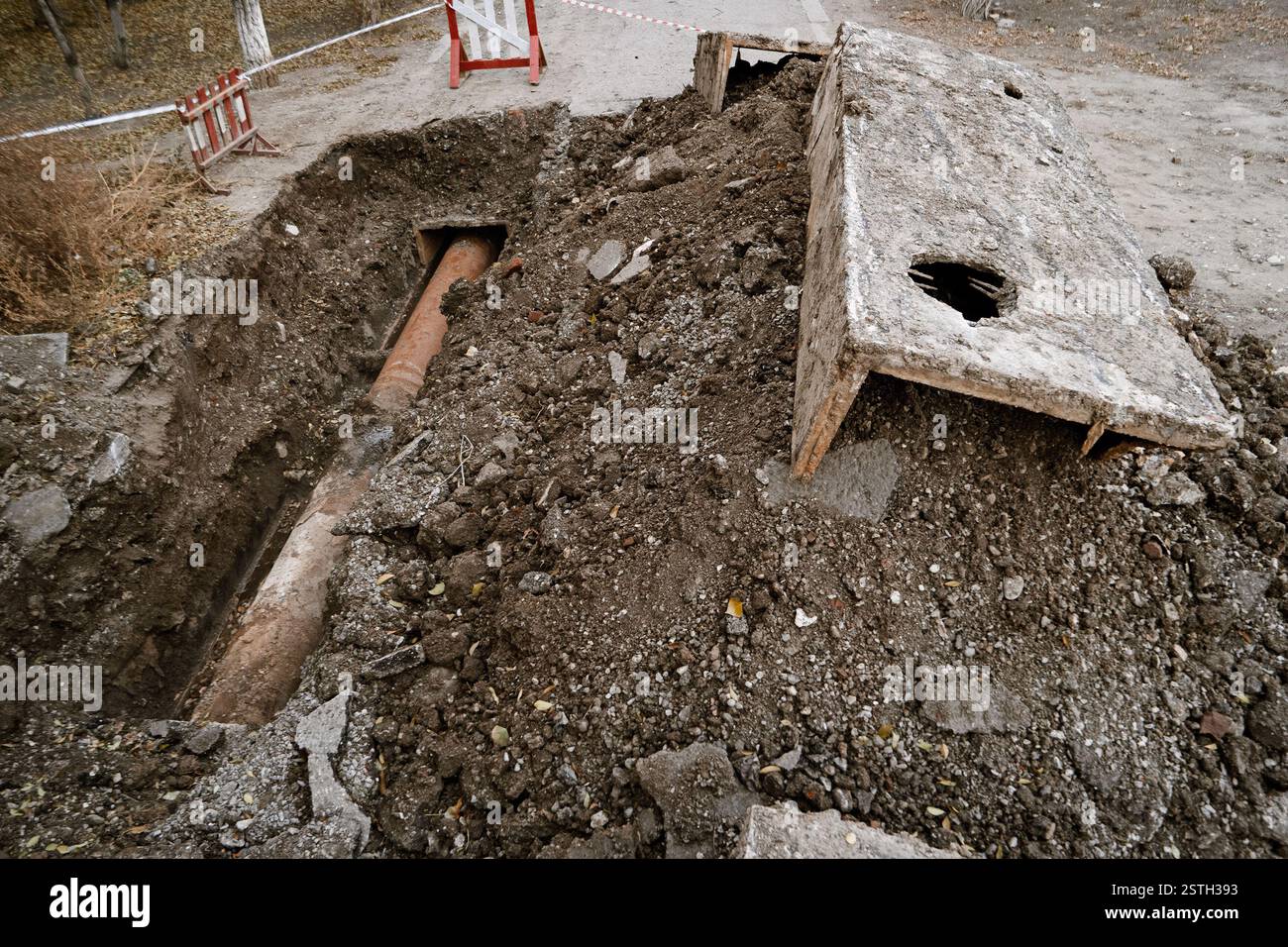 Rusty water pipe in a trench ground from above view. Repairing of the ...