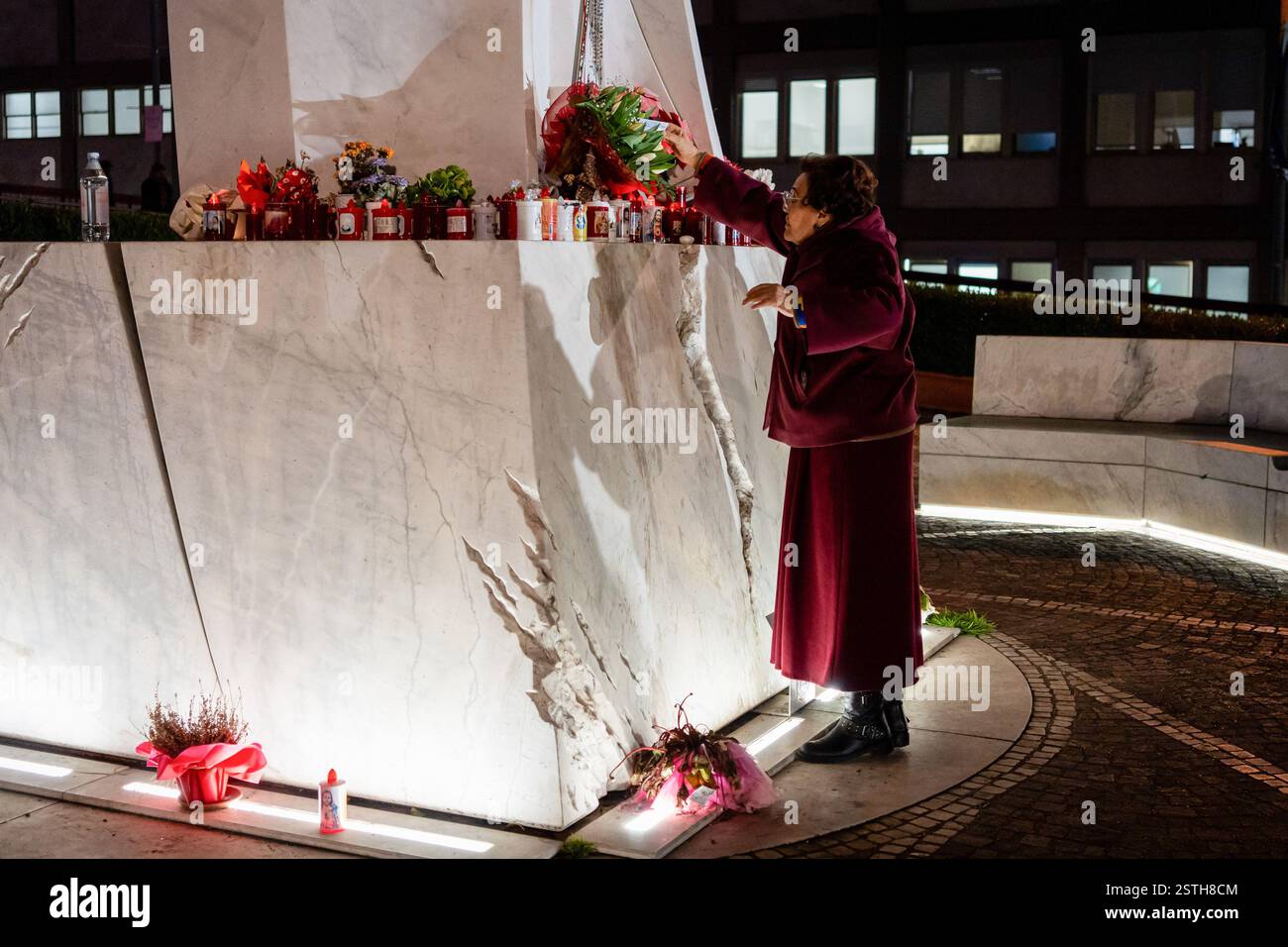 A woman carries flowers under the statue of Pope John Paul II at the ...
