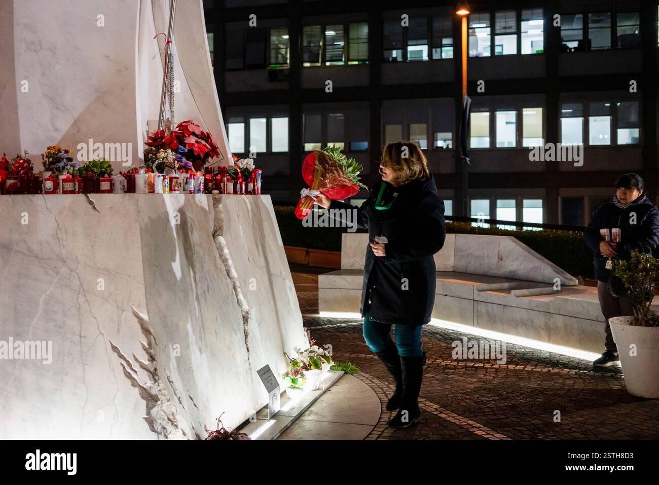 Rome, Italy. 18th Feb, 2025. A woman carries flowers under the statue ...