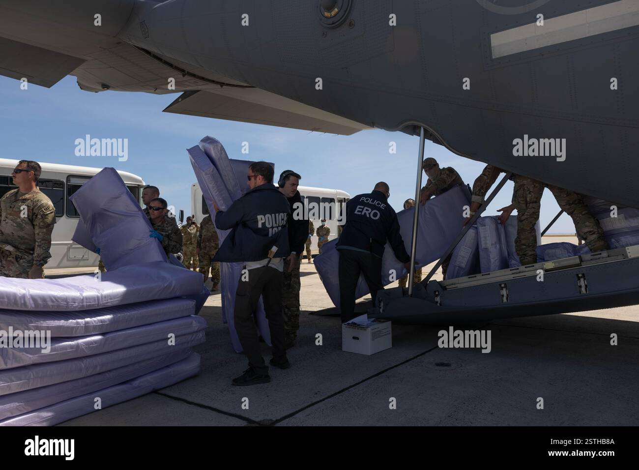 U.S service members assist interagency partners unload supplies as a ...