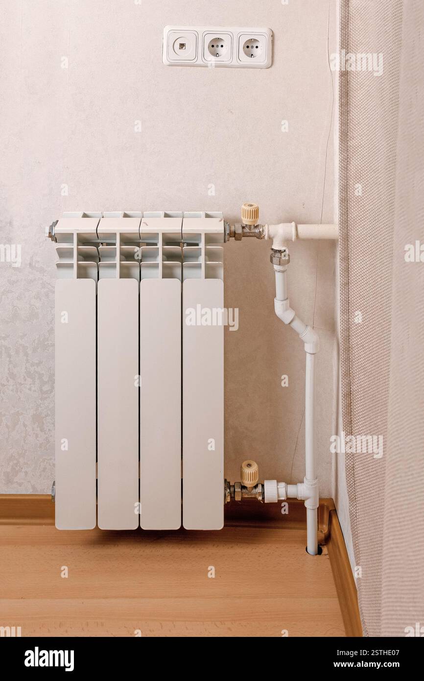 Modern hot water radiator on the wall Stock Photo - Alamy
