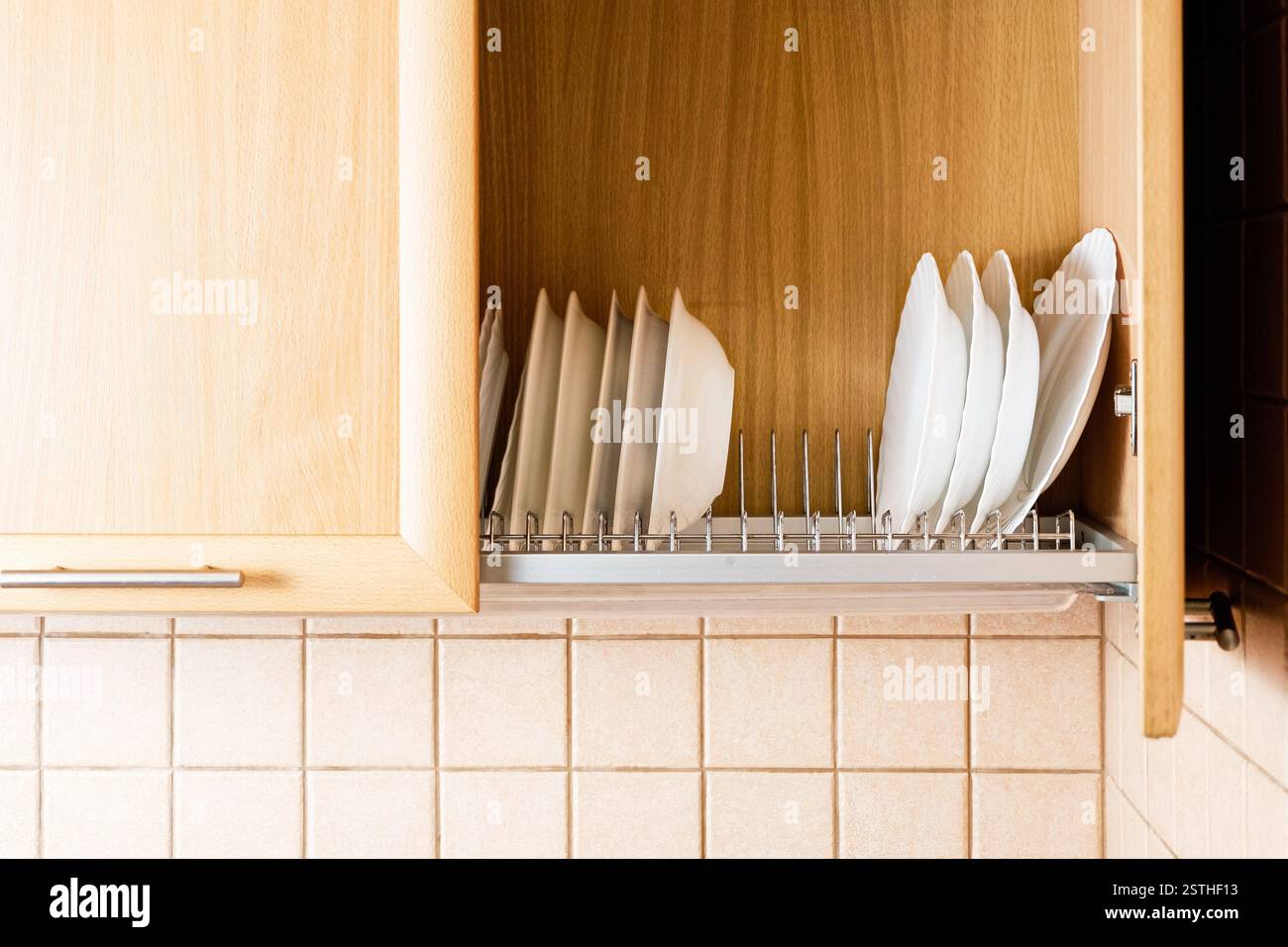 Dishes inside kitchen cupboard with open door Stock Photo - Alamy