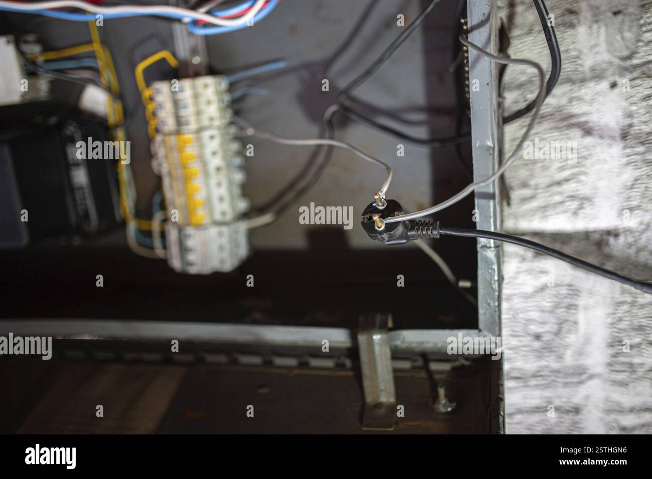Close-up of electrical wires and a circuit board inside a metal box ...