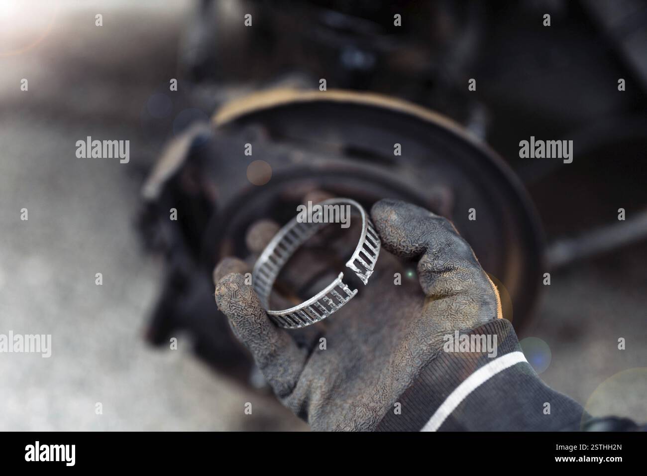 Mechanic holding a gear piece during car wheel repair Stock Photo - Alamy