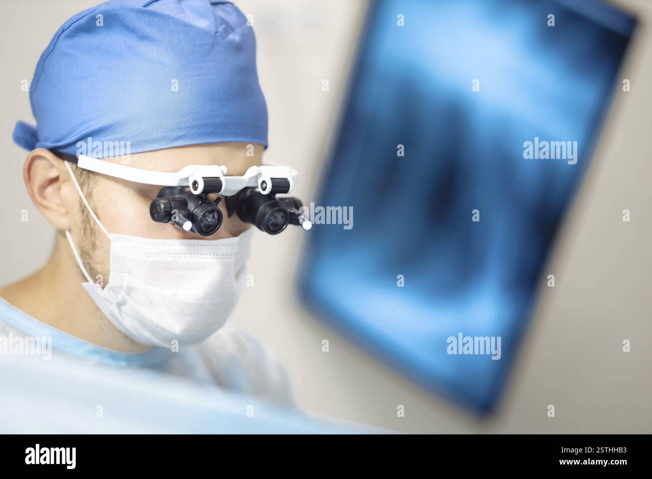 Surgeon with magnifying glasses focused during a medical procedure ...