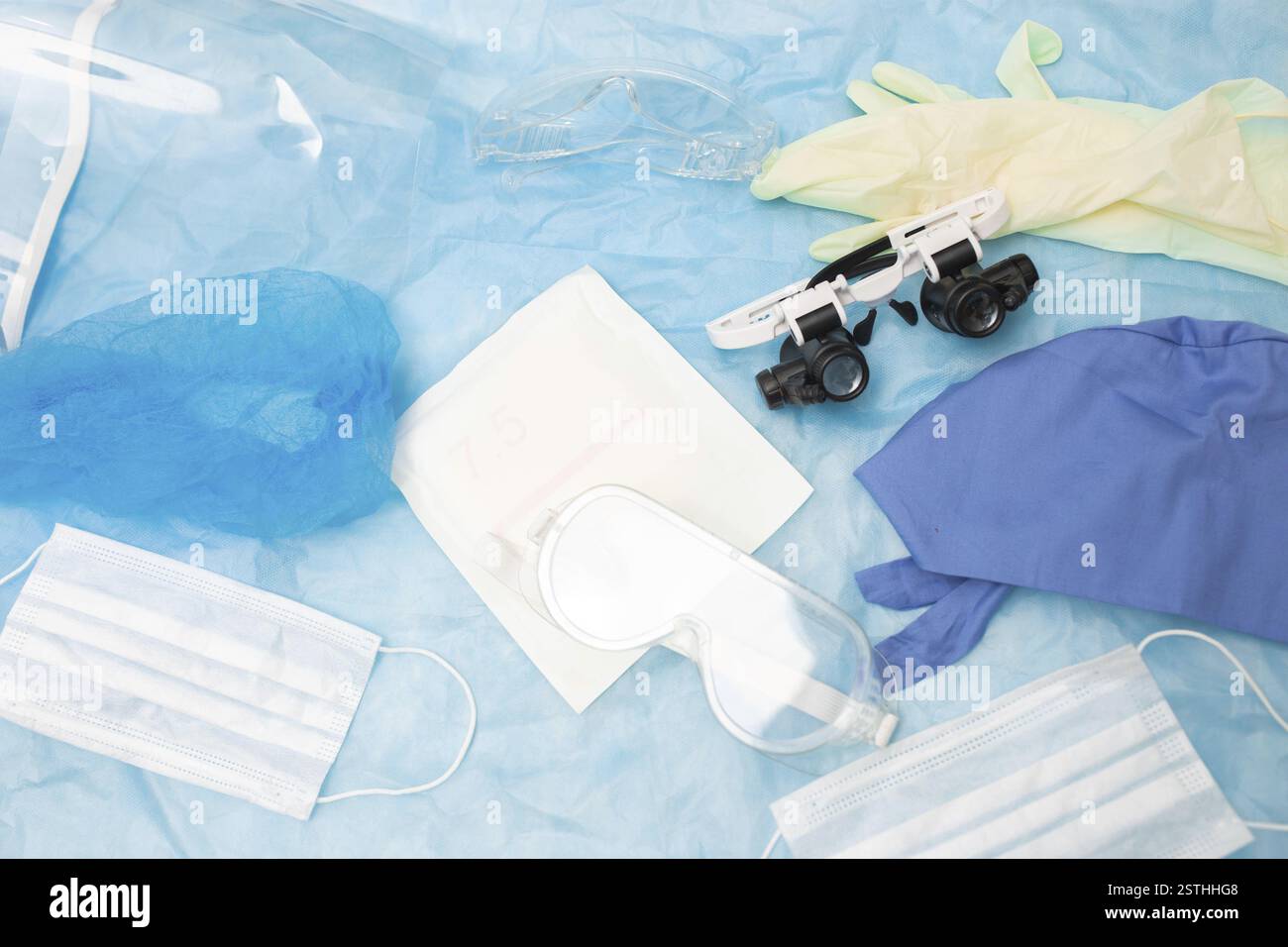 Medical protective items like goggles, masks, and caps spread out on a ...
