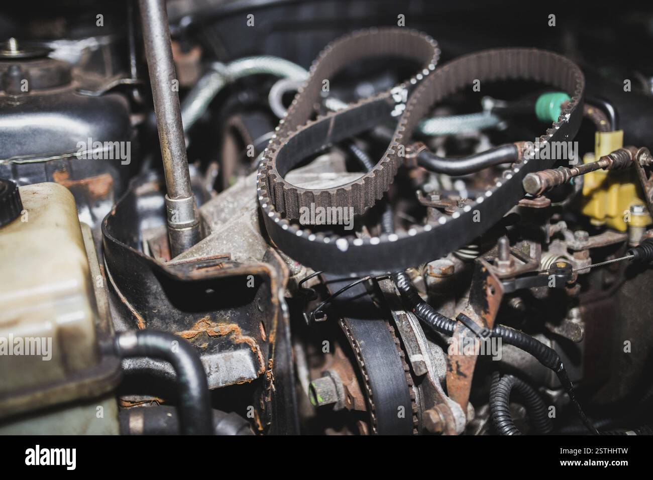 A closer view of an installation of a timing belt within a car engine ...