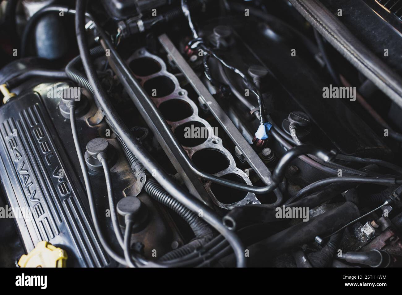 Close-up of a car engine with visible components and cables suggesting ...