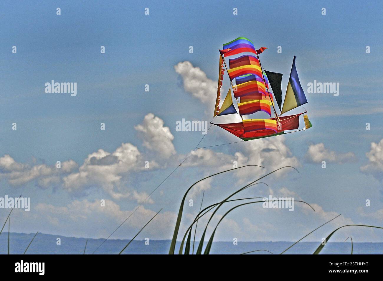 A flying dragon in the shape of a ship against a blue sky, Bali ...