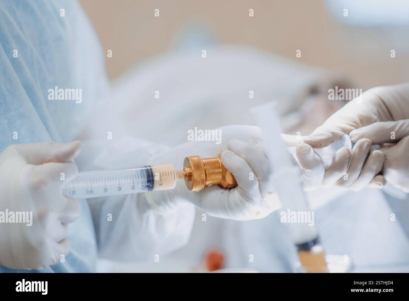 Close-up of a syringe handled by healthcare professionals, showcasing ...