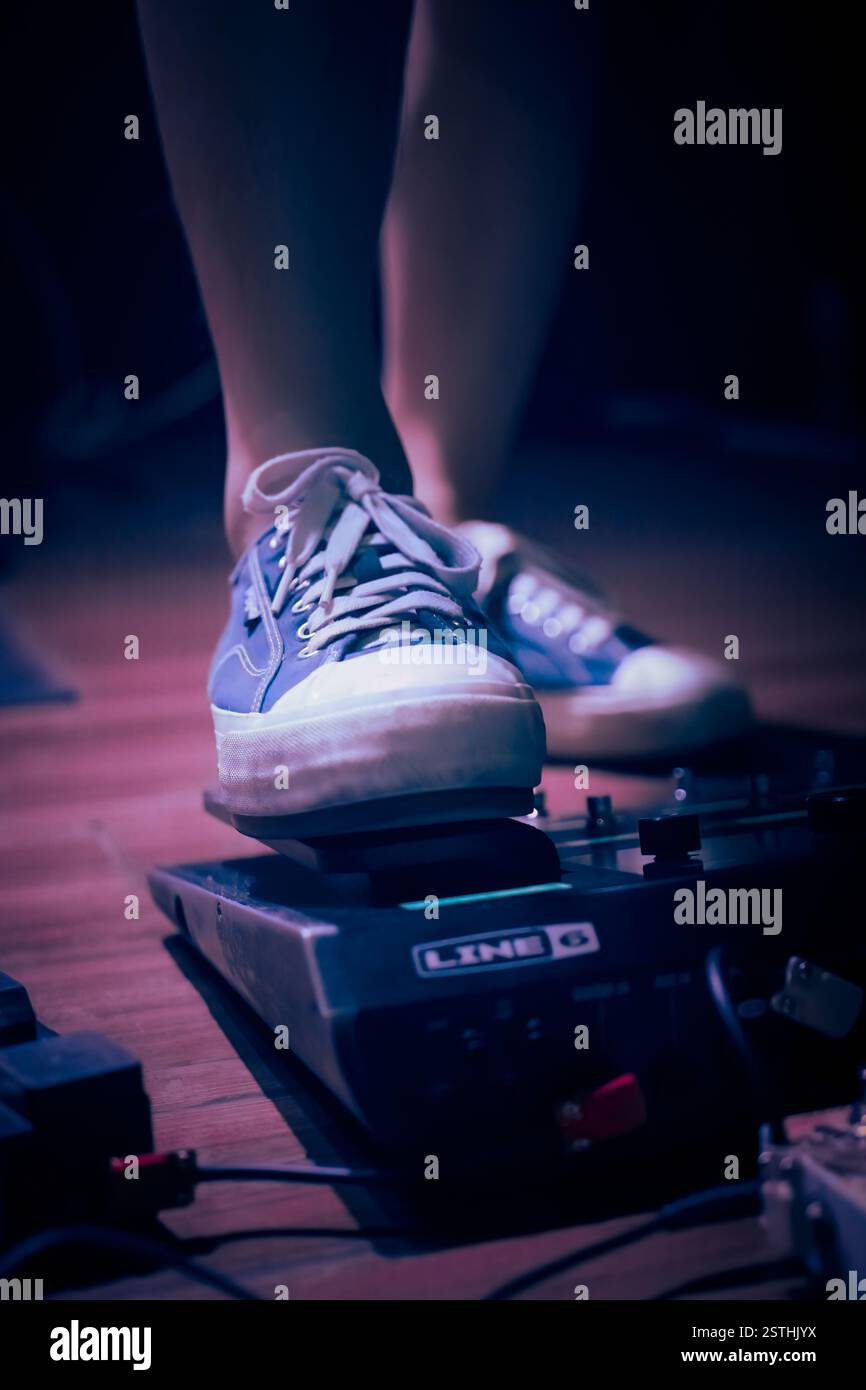 Close-up of a musician’s foot pressing a Line 6 effects pedal during a ...