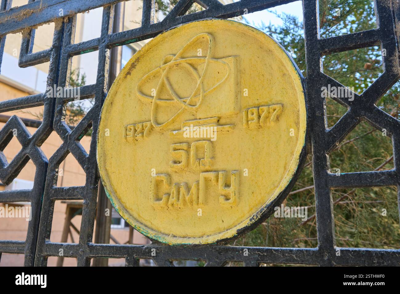 A Soviet era gold medallion on a university fence, honoring 50 years of ...