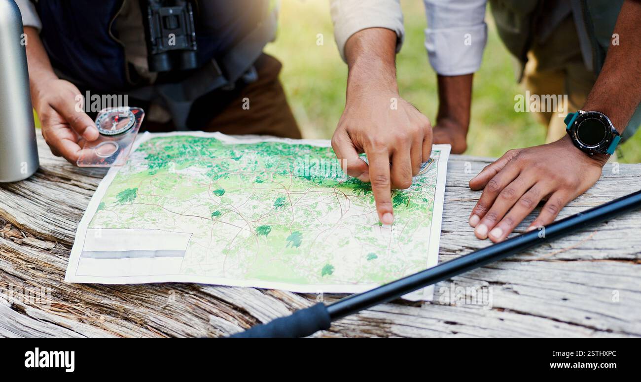 Hands, people and maps with compass for hiking of trekking direction ...