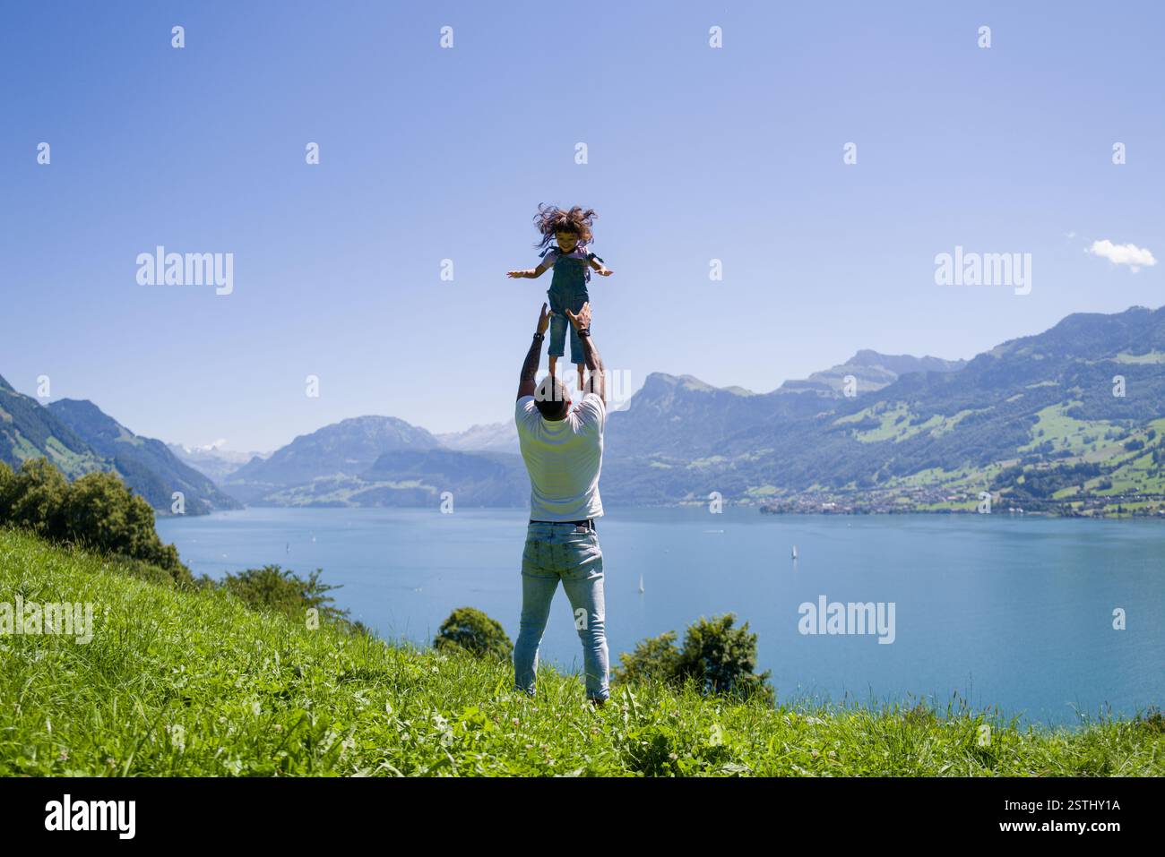 Happy dad playing with child on nature. Father lifting, throwing child ...