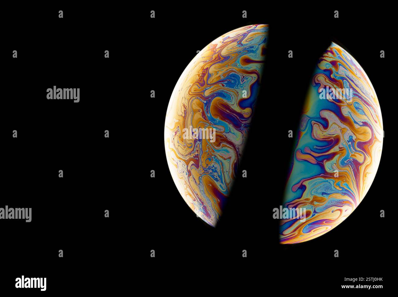 Two of colorful soap bubbles in the shape of ball on a black background ...