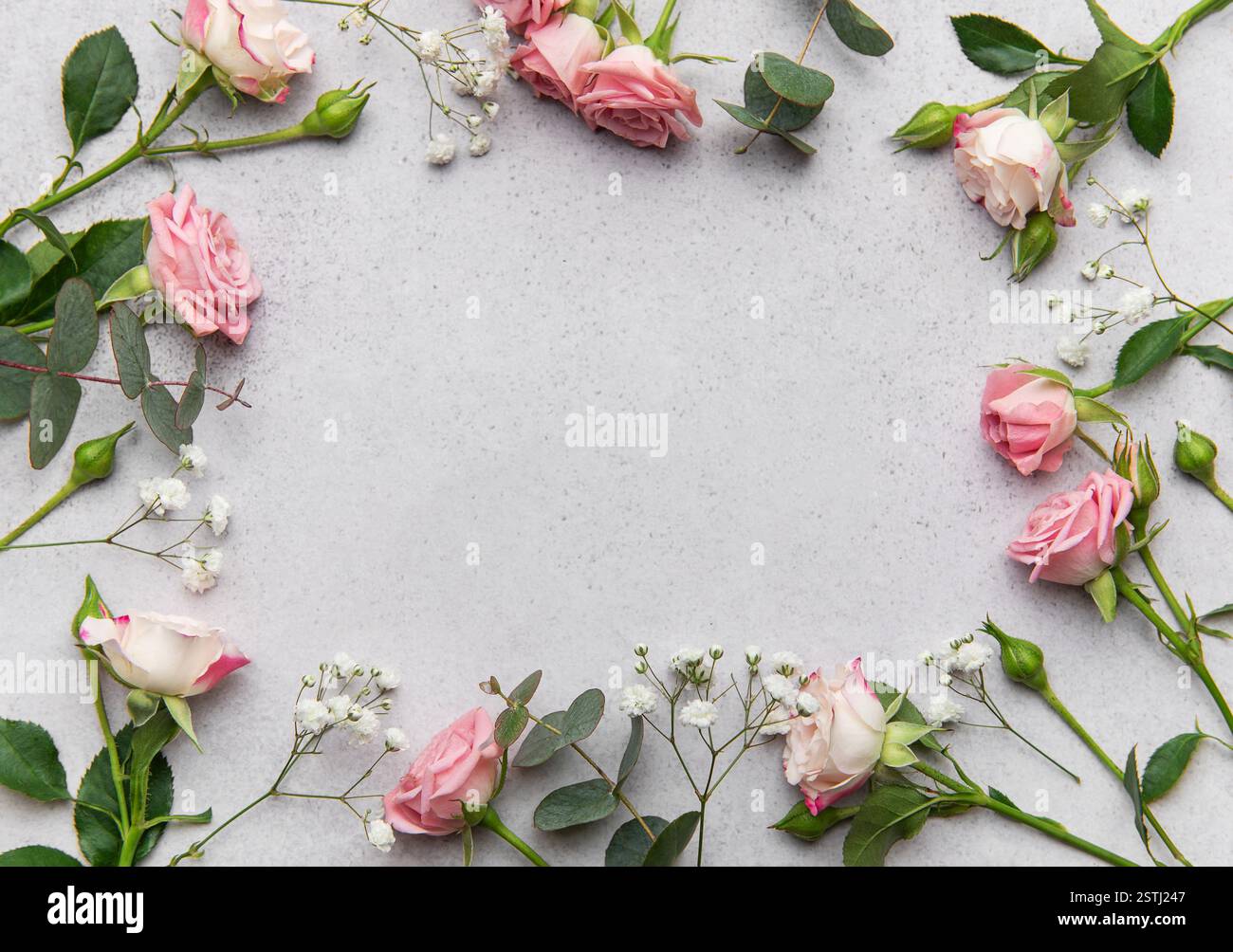 Pink roses, eucalyptus leaves, and baby's breath flowers are creating a ...