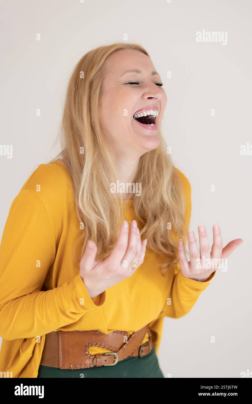 Portrait of confident beautiful woman laughing, with long blende hair ...